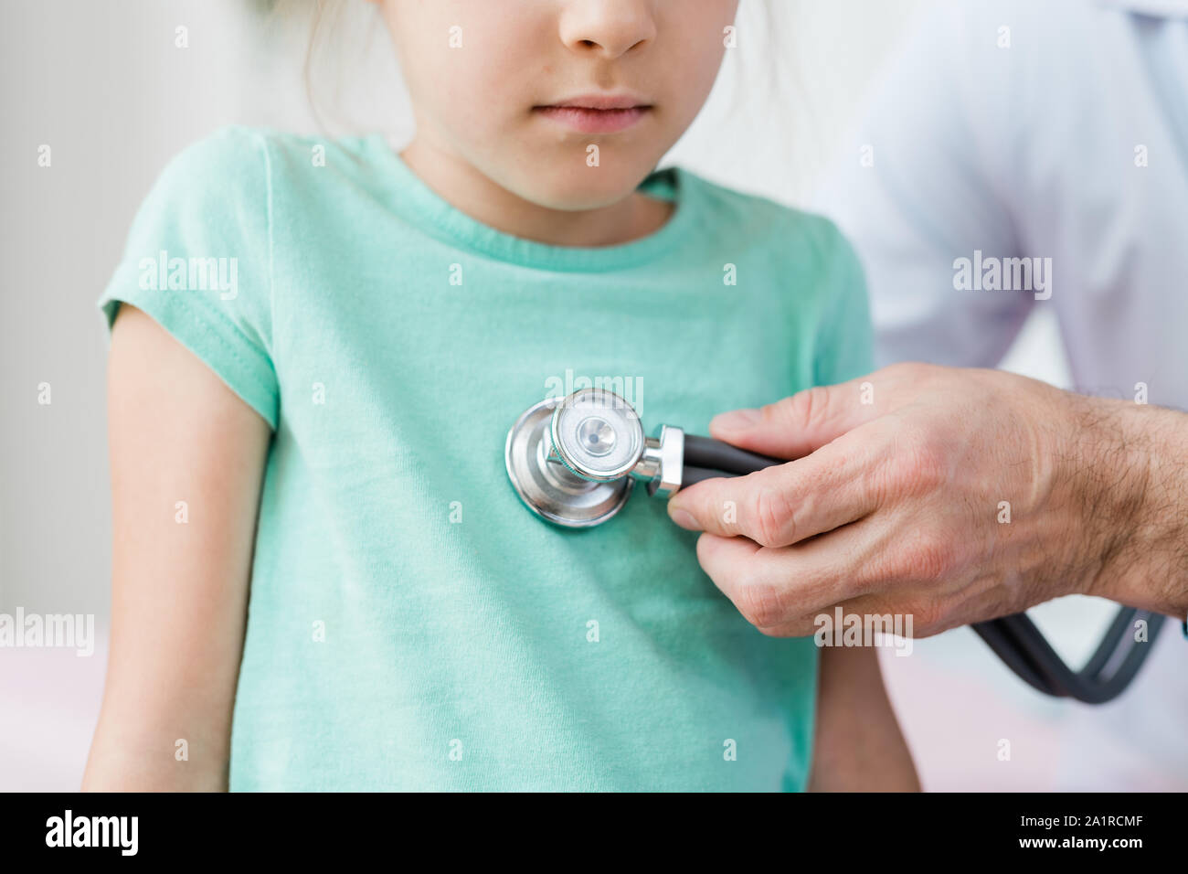 Hand of young pediatrician holding stethoscope while putting it to ...