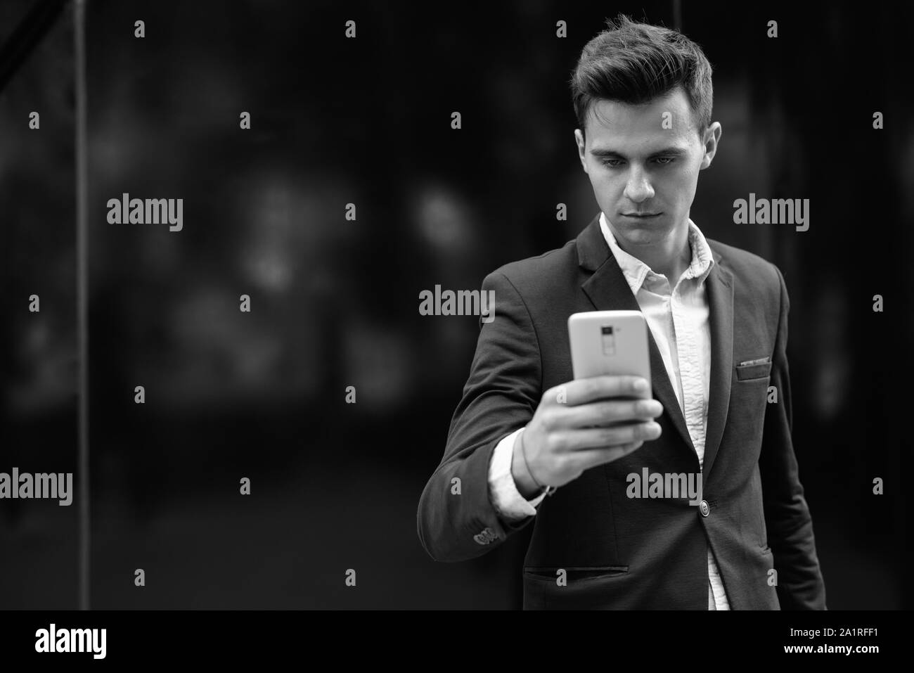 Young modern businessman using mobile Black and White Stock Photos ...