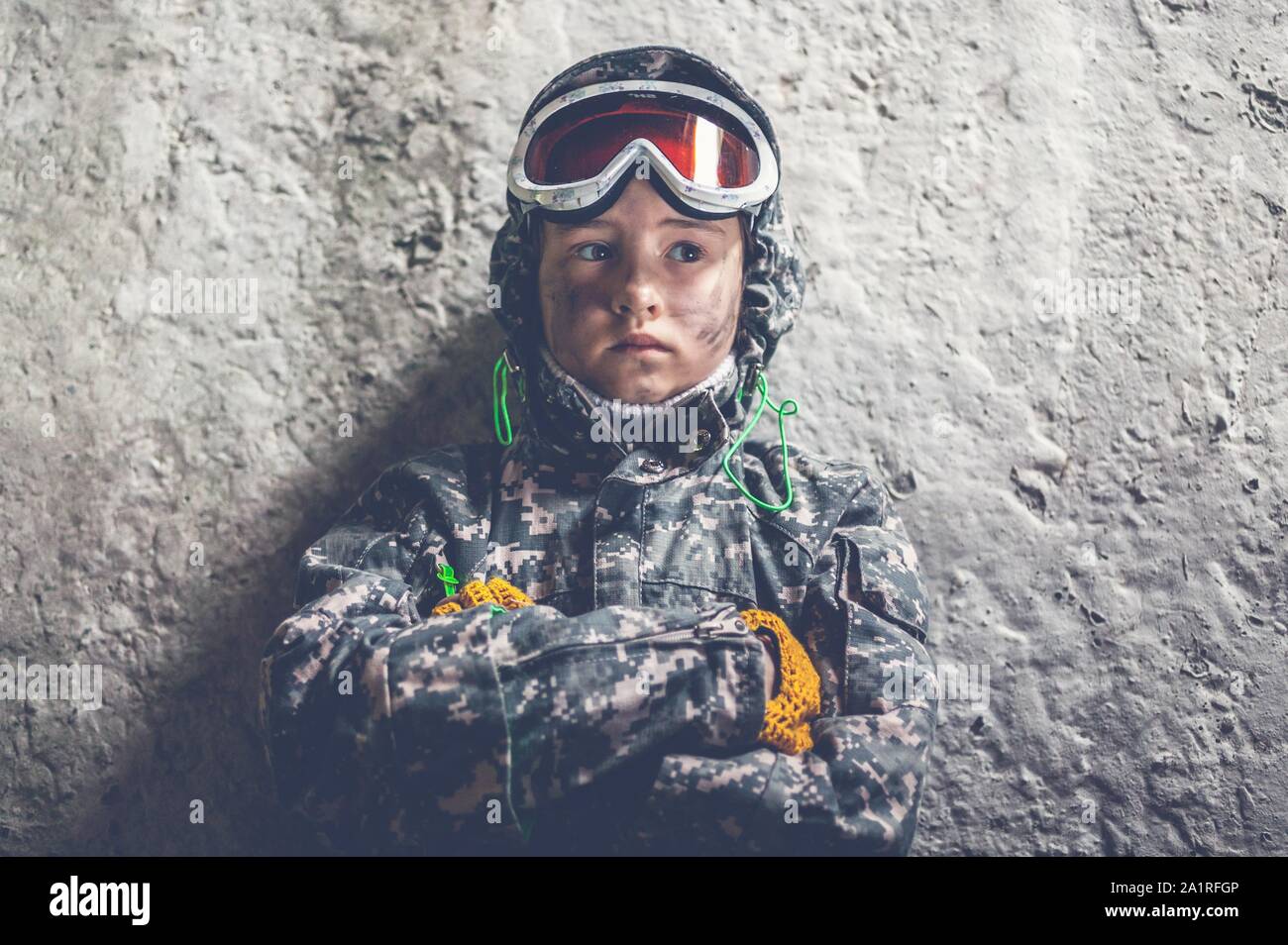 Serious child in military uniform. Disappointed kid with crossing arms ...