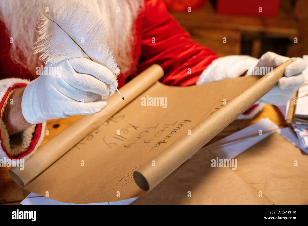 Gloved Santa holding pen over big paper with list of kids names while ...