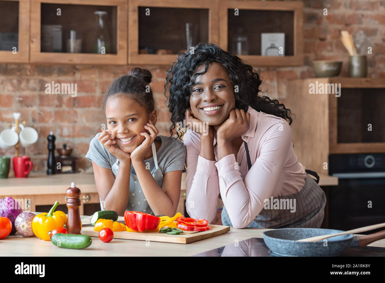 Mom and daughter posing on camera while cooking Stock Photo - Alamy