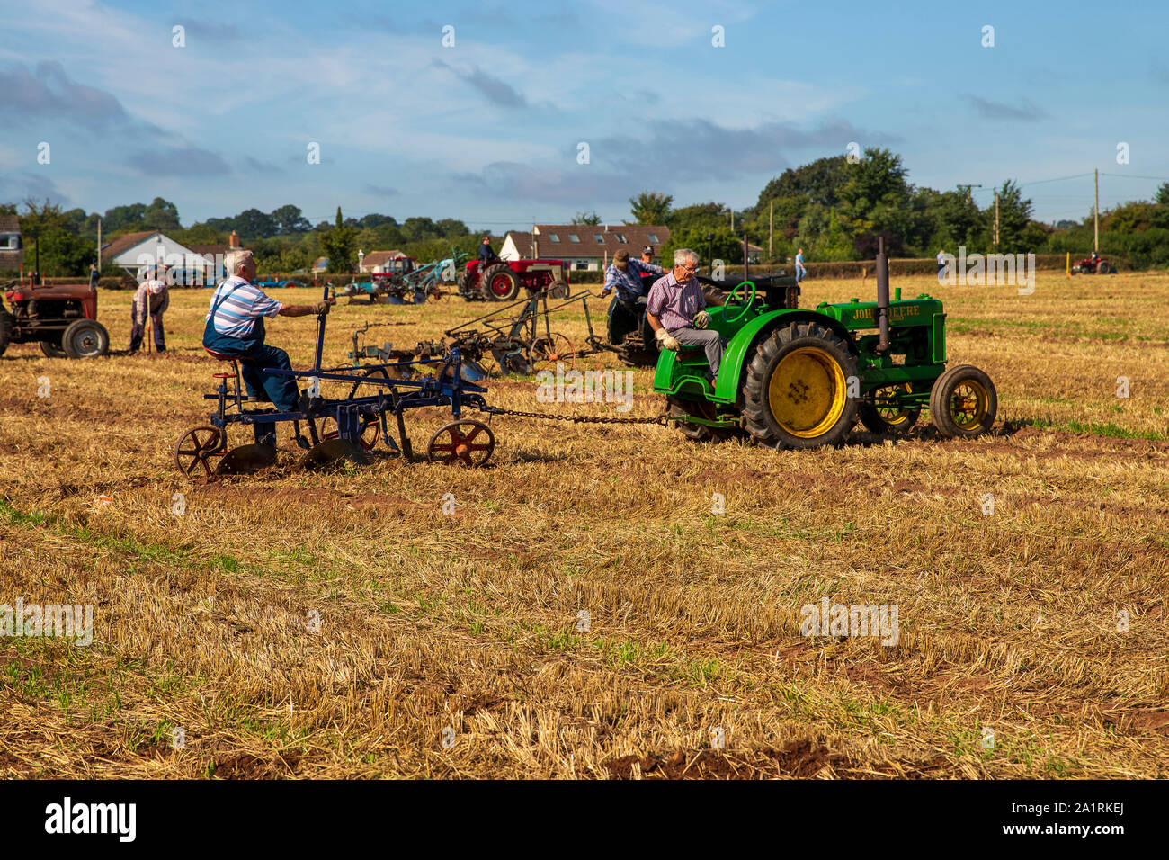 2 Farmers Ploughing using a John Deere General Purpose Vintage Tractor ...
