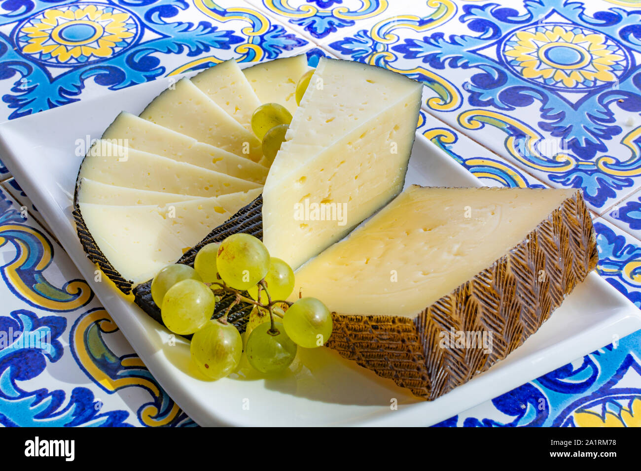 Spanish sheep cheese served with white grapes on andalusian style table ...