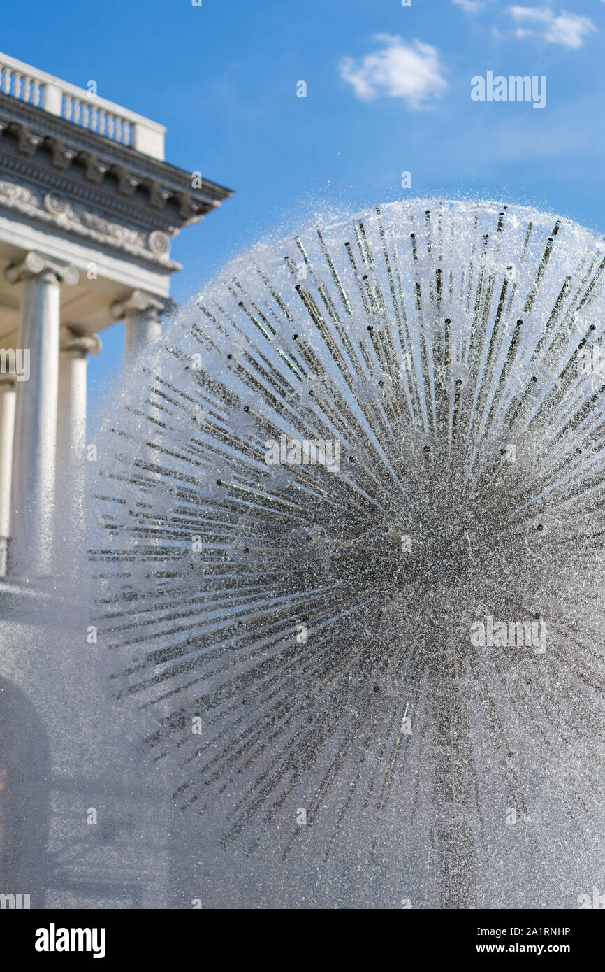 Round fountain against the blue sky. A modern ball-shaped fountain ...