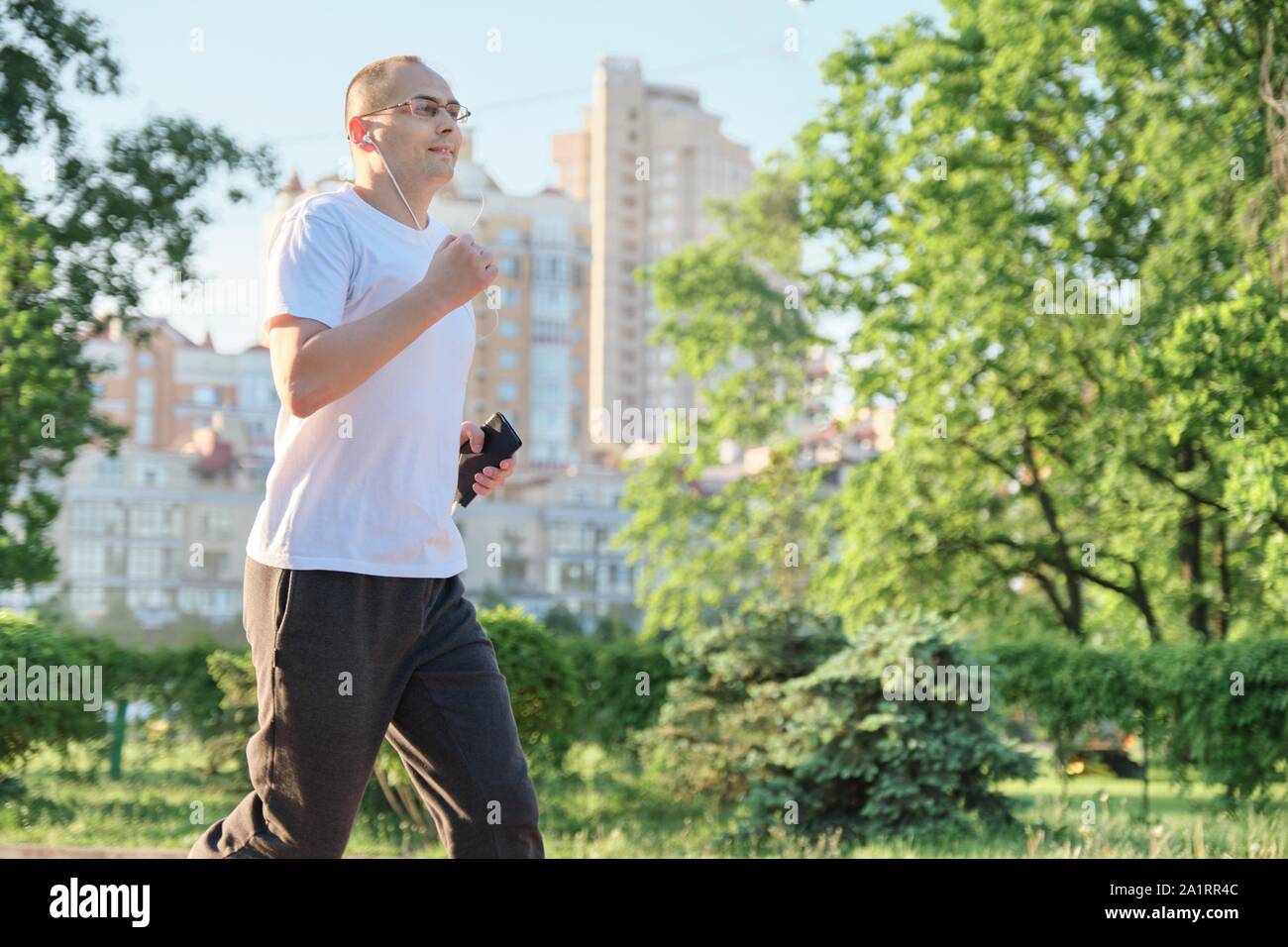 Middle-aged man running in the park, active healthy sports lifestyle of ...