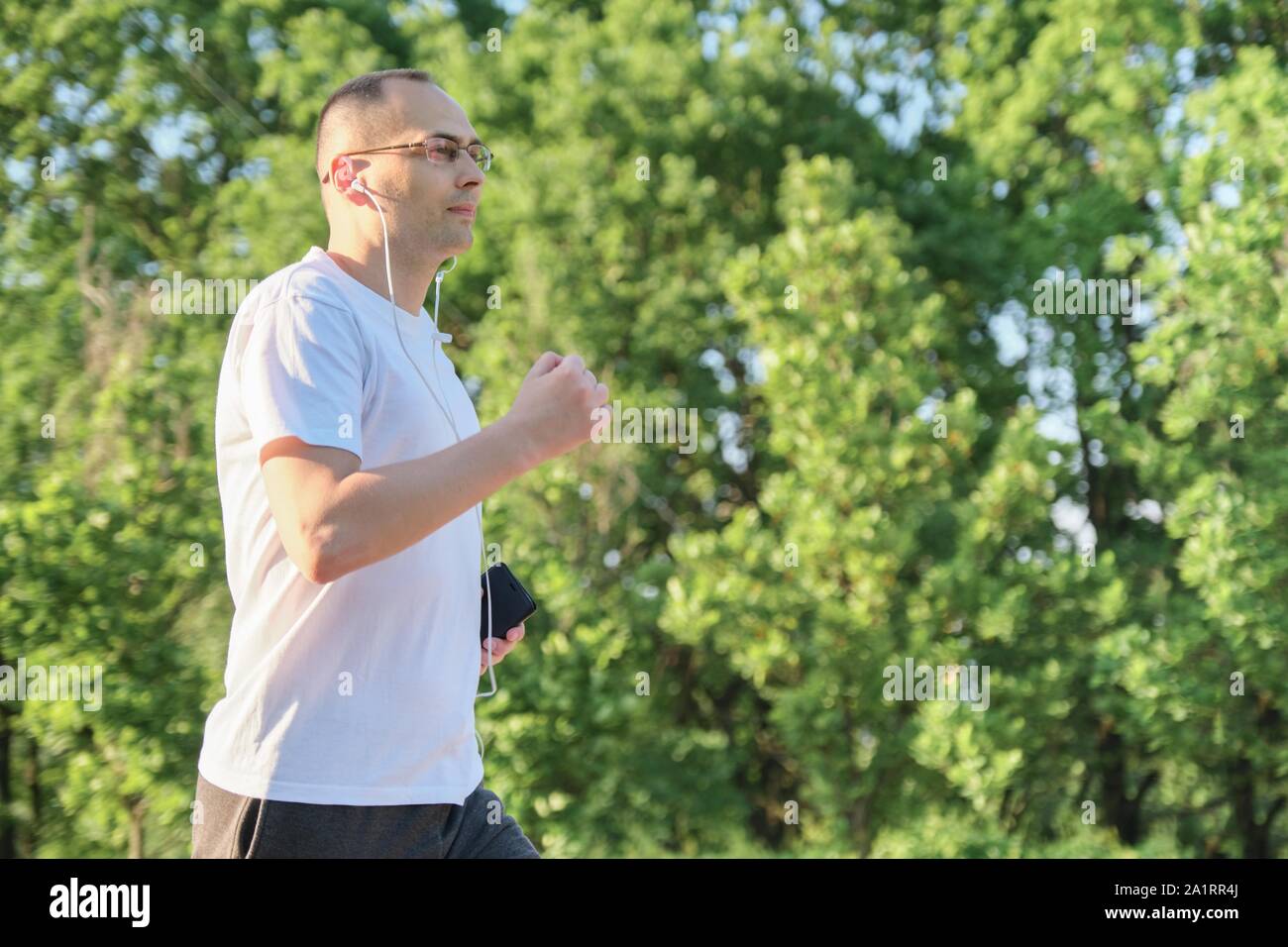Middle-aged man running in the park, active healthy sports lifestyle of ...