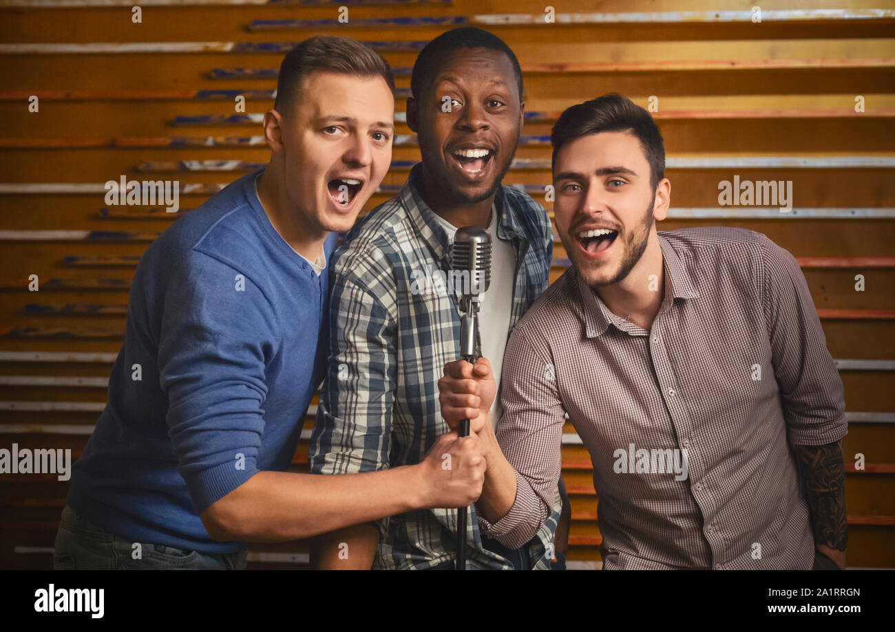 Happy young fellows singing at karaoke bar Stock Photo - Alamy