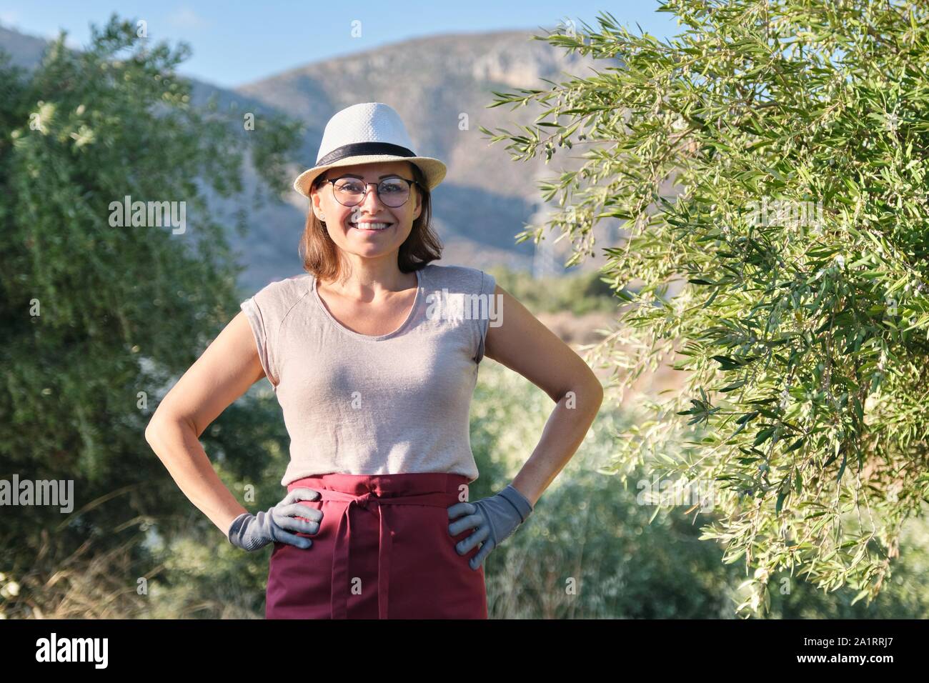 Portrait of confident woman olive farm owner, background olive trees in ...