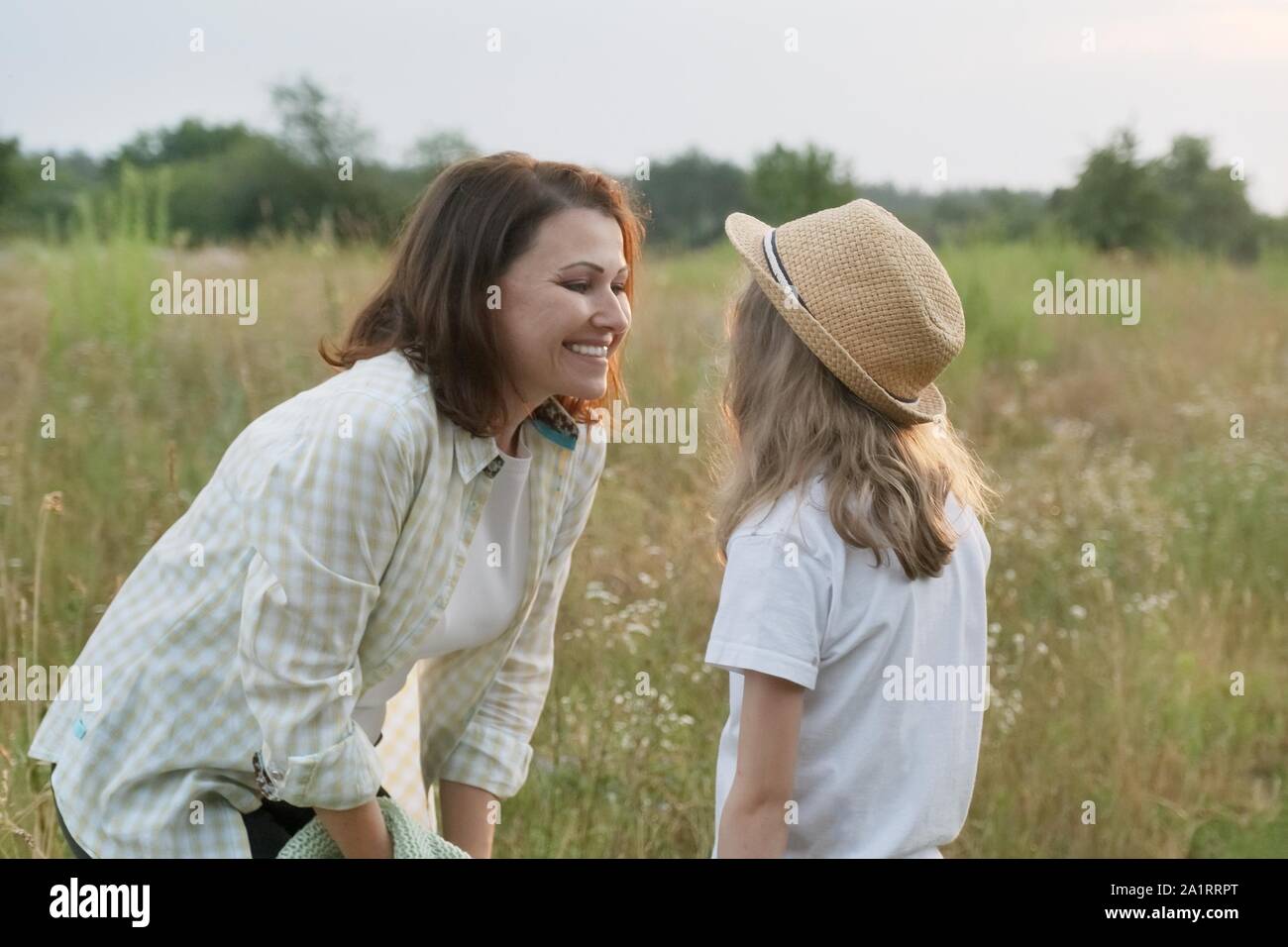 Smiling mother talking with child daughter. Happy loving family, summer ...