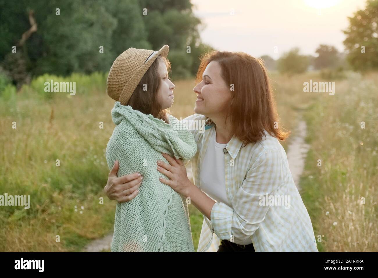 Mother and daughter talking embracing, summer nature background golden ...