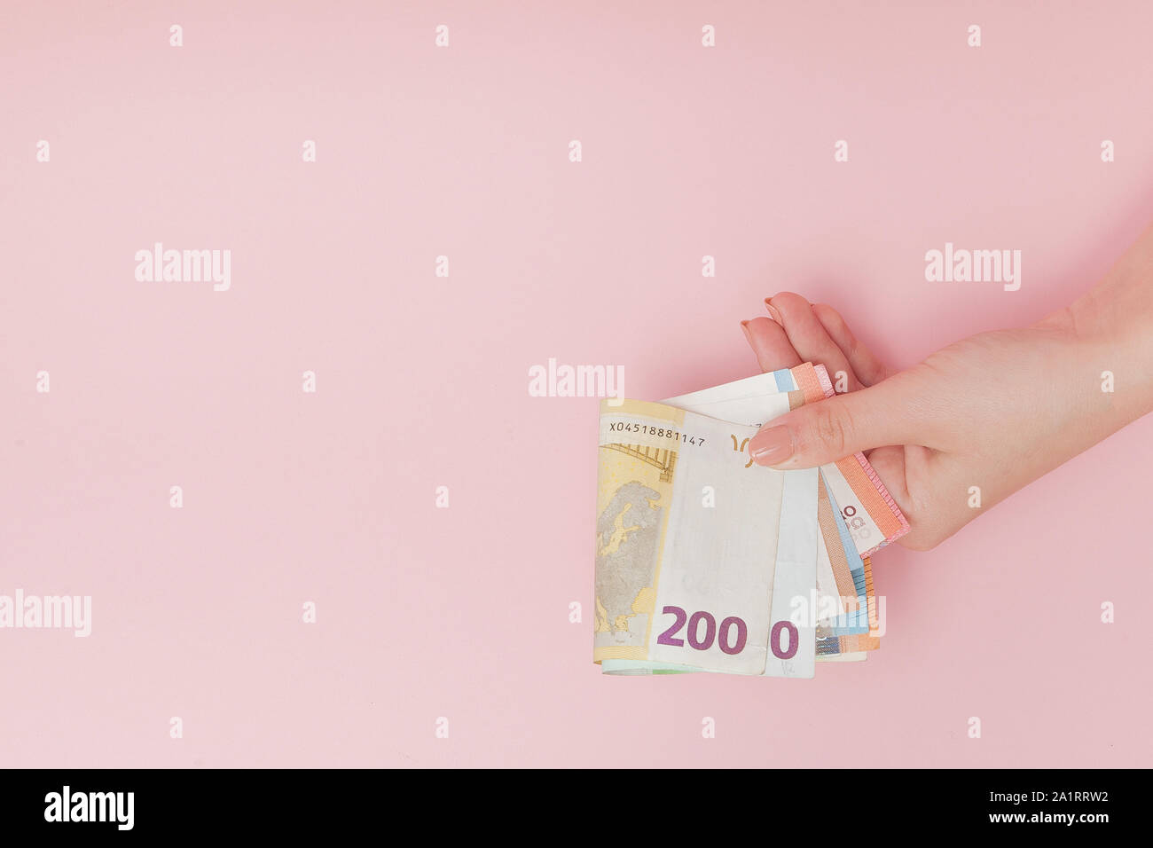 Euro banknotes money in female hands on pink background. Business ...