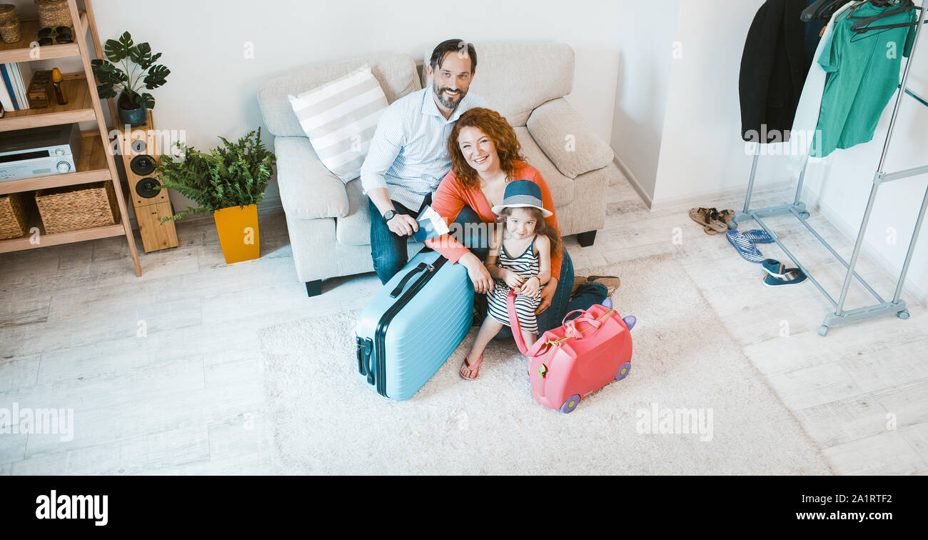 Happy family going on vacation, sitting on couch with suitcases Stock ...