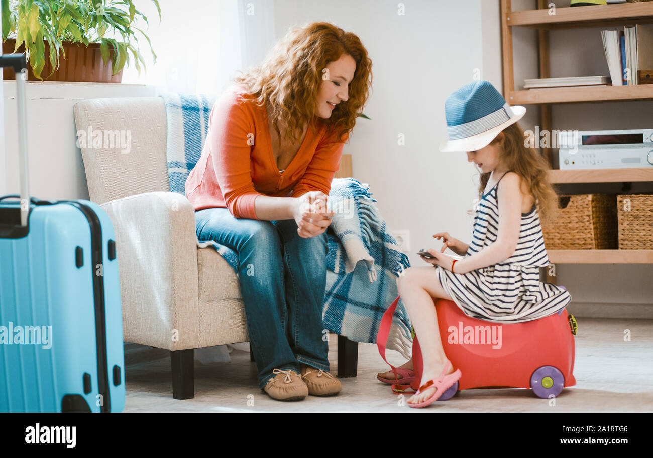 Family travel, mom and daughter sitting at home ready to leave Stock ...