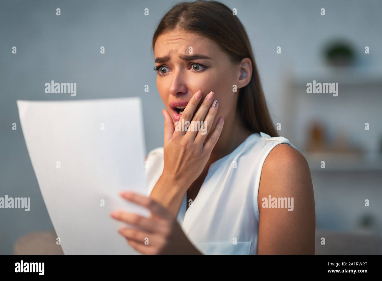 Shocked Girl Reading Unexpected Bad News Letter Standing At Home Stock ...