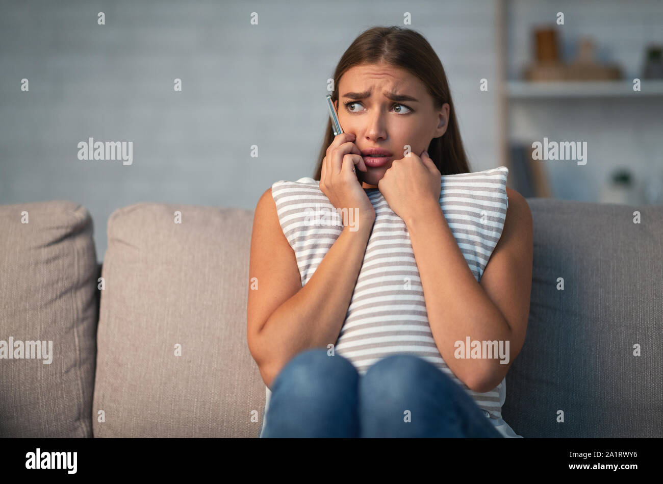 Scared Woman Calling The Police Sitting On Couch At Home Stock Photo ...