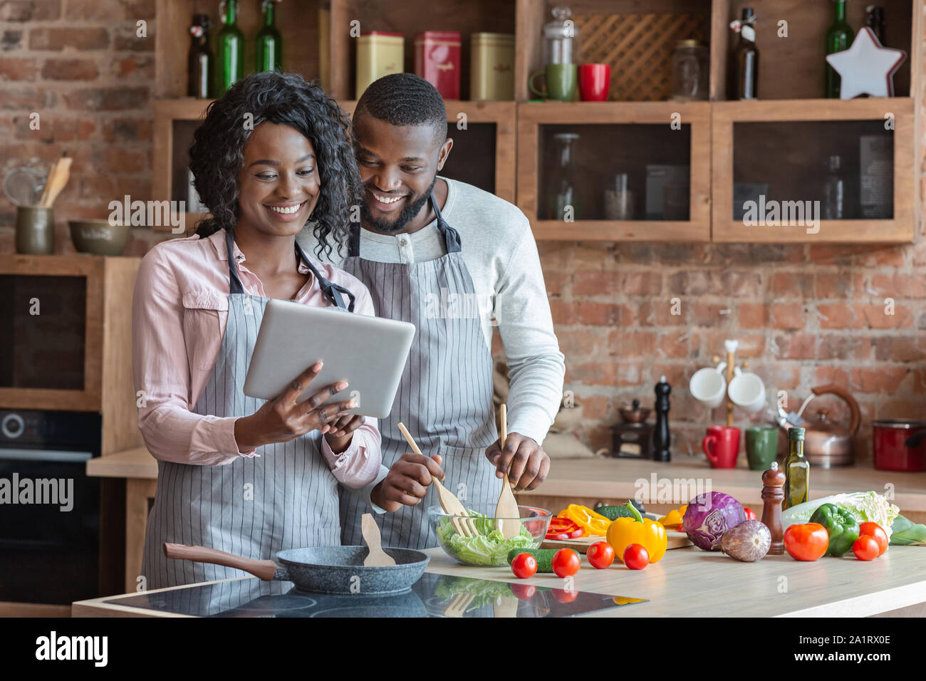 Black couple using digital tablet in kitchen Stock Photo - Alamy