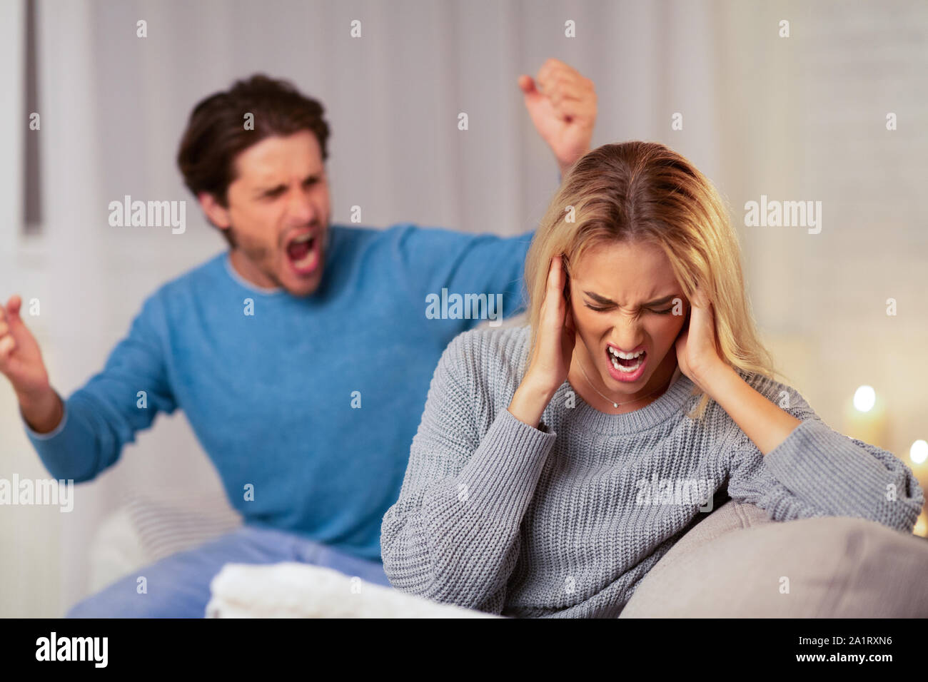 Aggressive Man Yelling At Girlfriend Sitting On Sofa At Home Stock ...