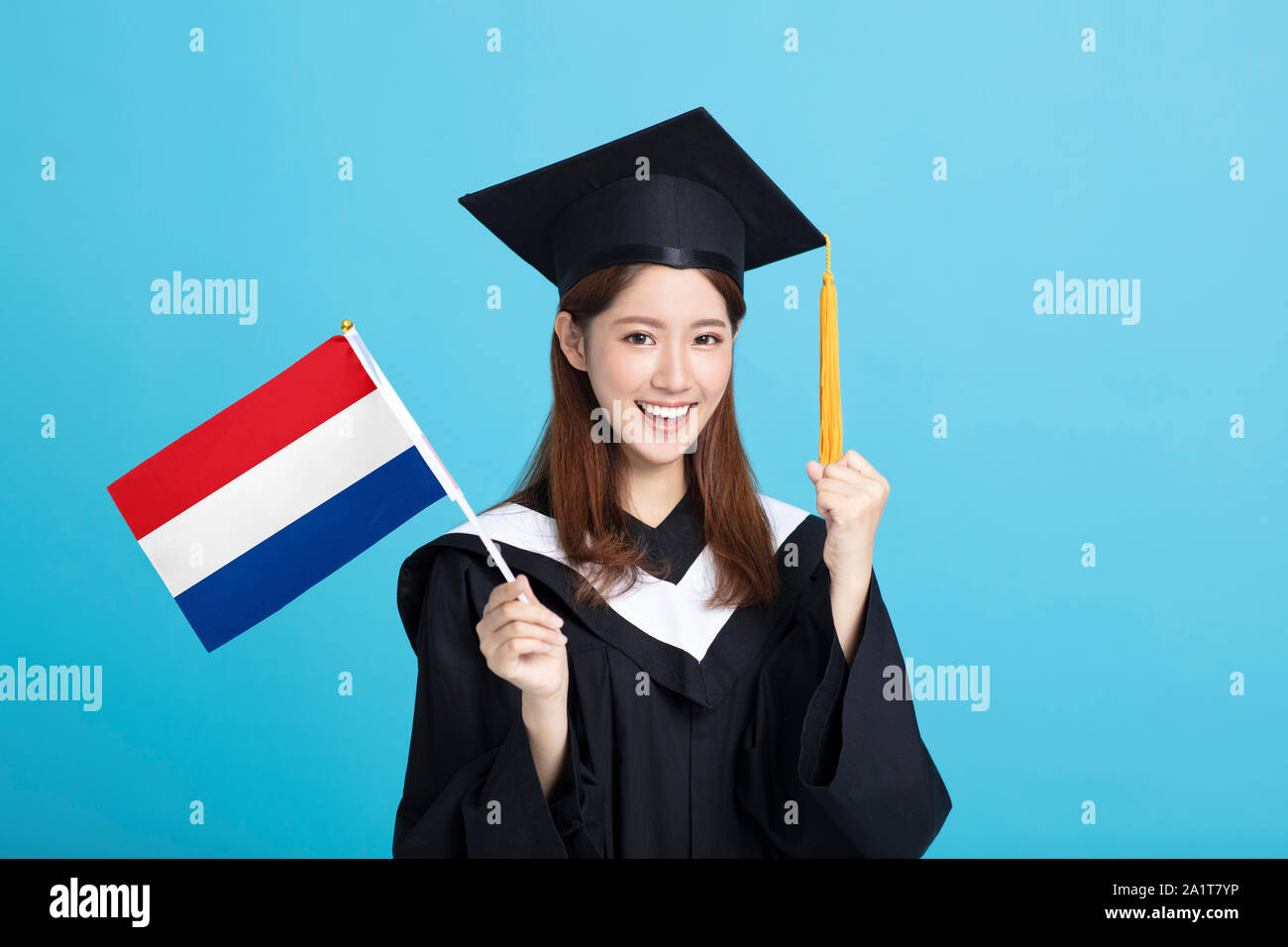 happy Young female graduation student showing the Netherlands flag ...
