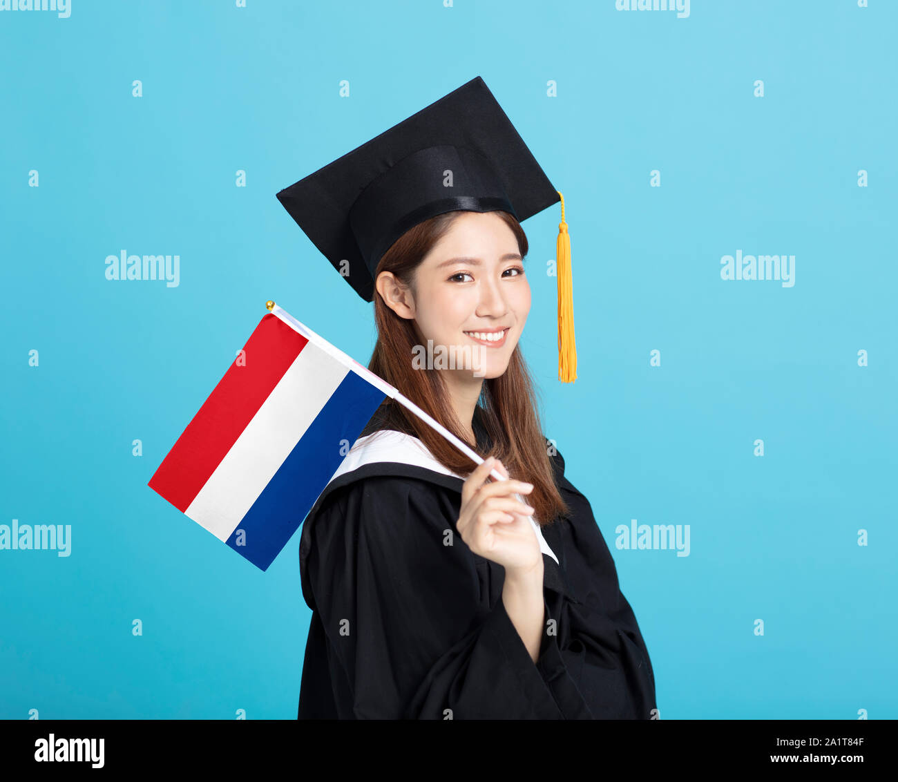 happy Young female graduation student showing the Netherlands flag ...