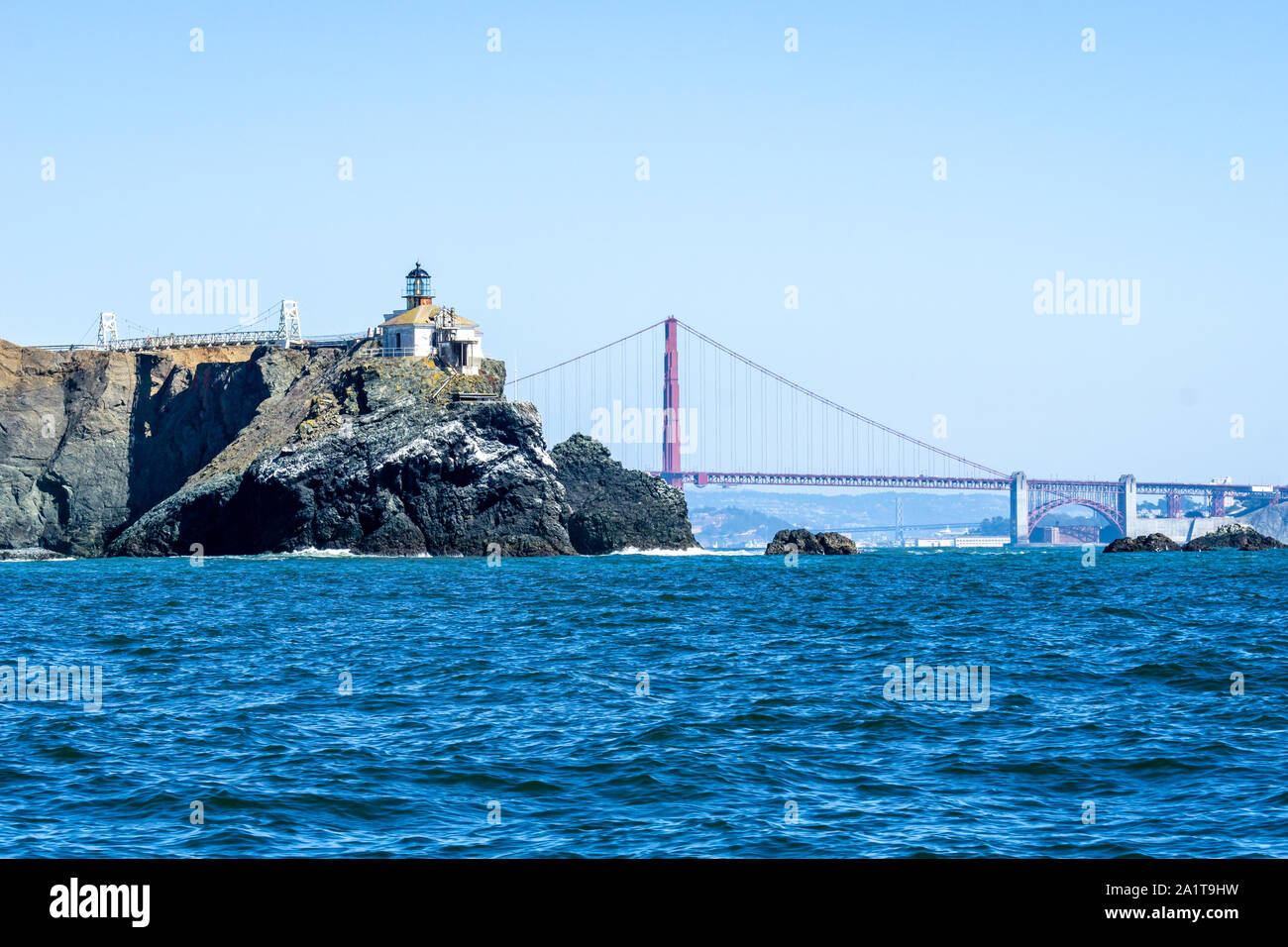 A view of the Golden Gate Bridge with a lighthouse in the foreground ...
