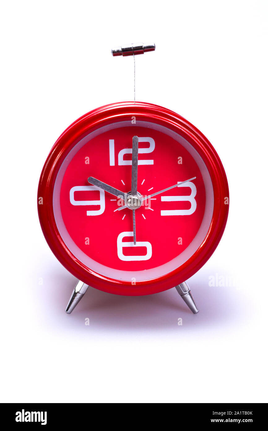 close up of red clock face on white background in portrait orientation ...