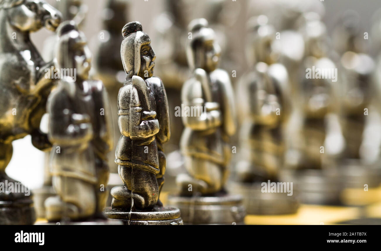 Silver chess pieces on a checkerboard blurry background Stock Photo - Alamy