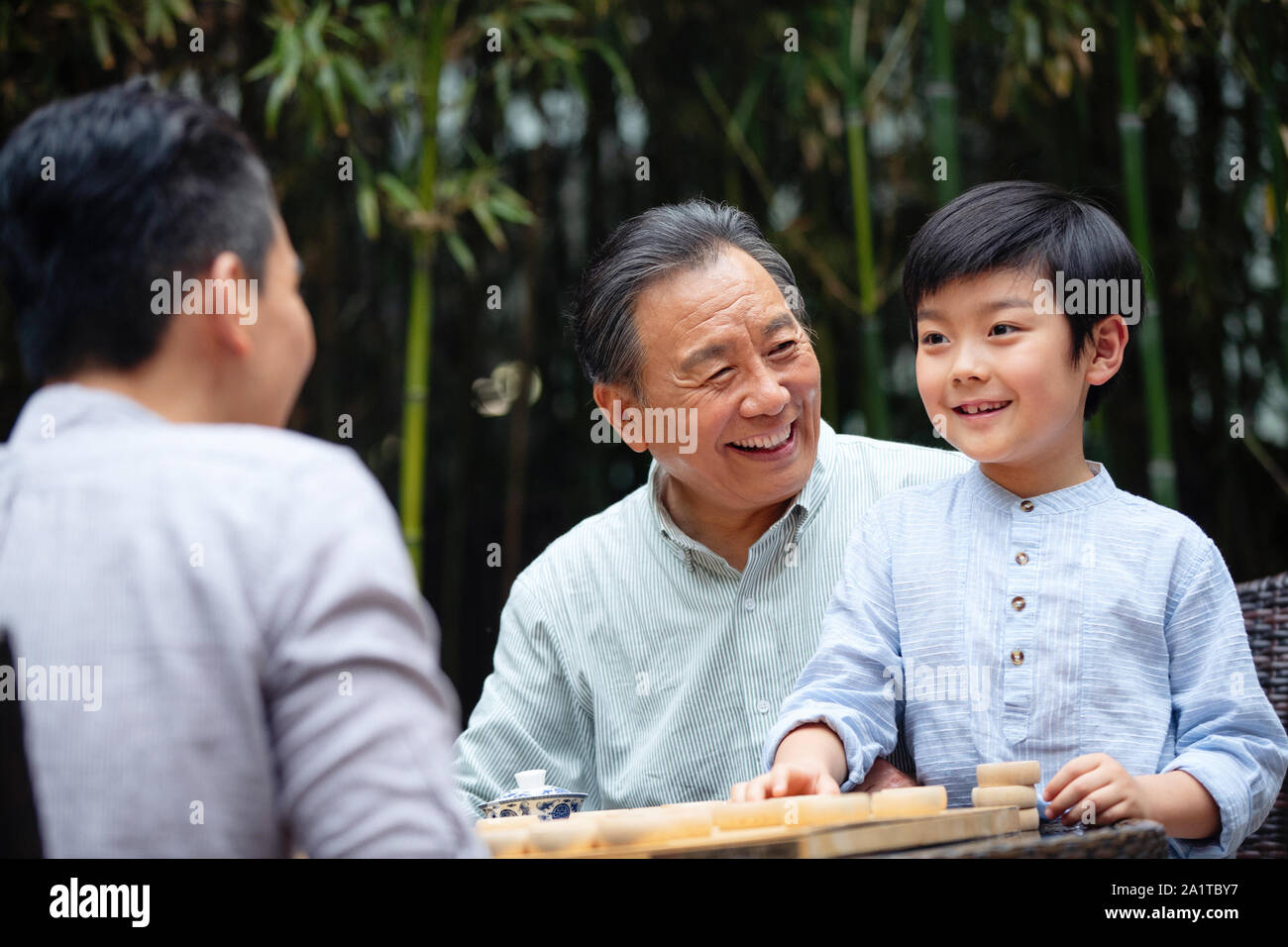 Three people playing chess between the two generations Stock Photo - Alamy