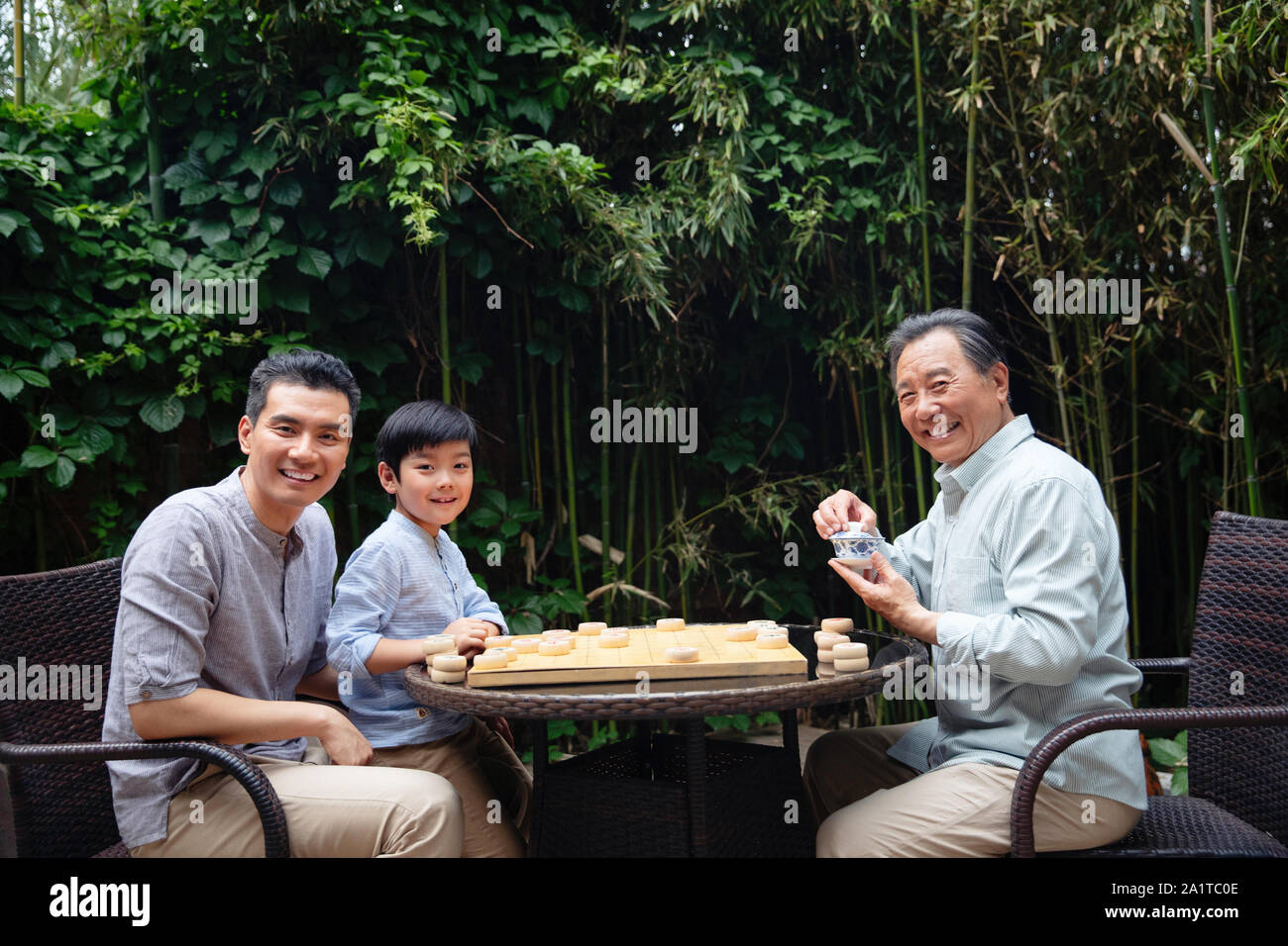 Three people playing chess between the two generations Stock Photo - Alamy