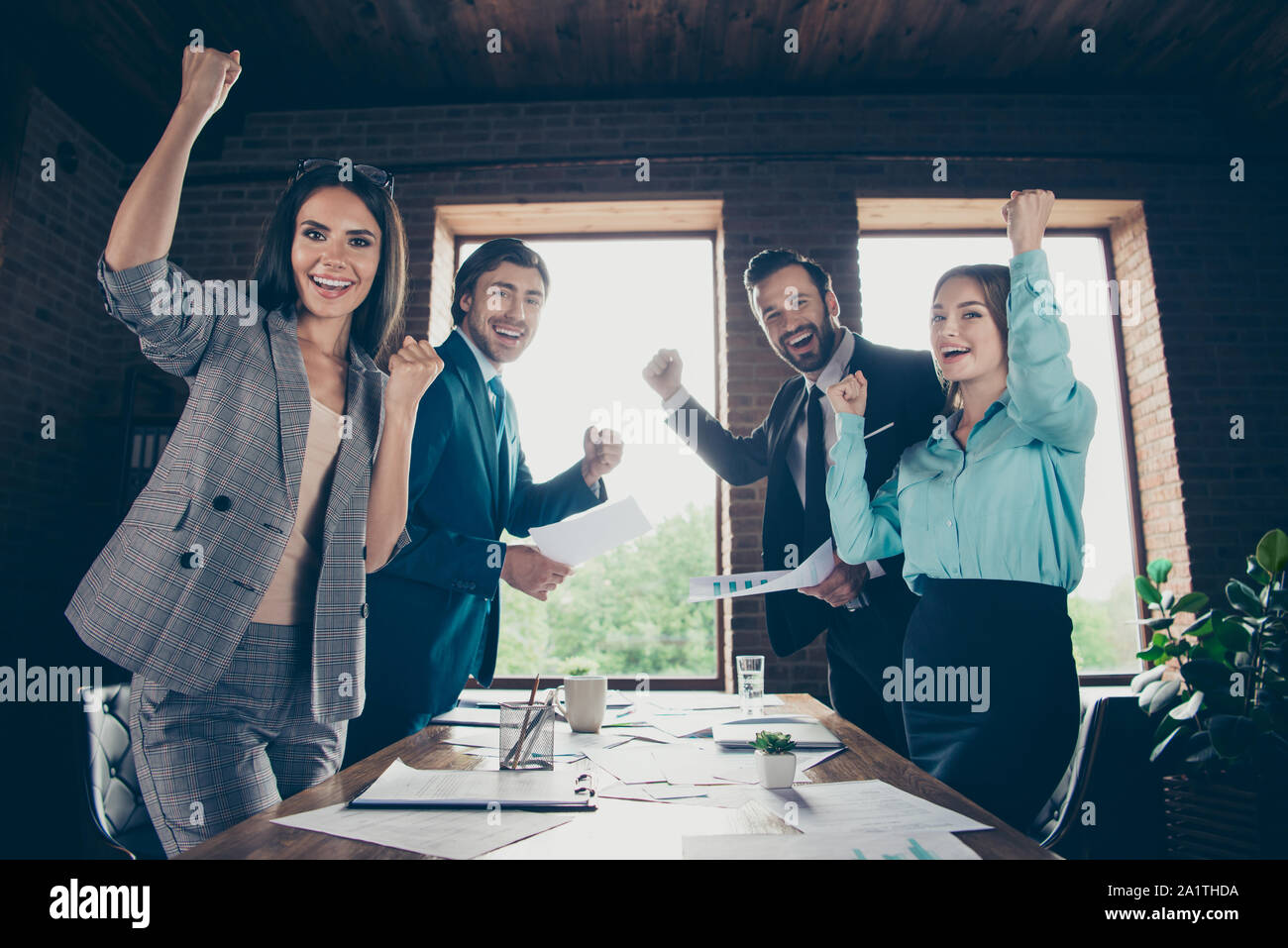 Low angle top view of four attractive person raised fists up peo Stock ...