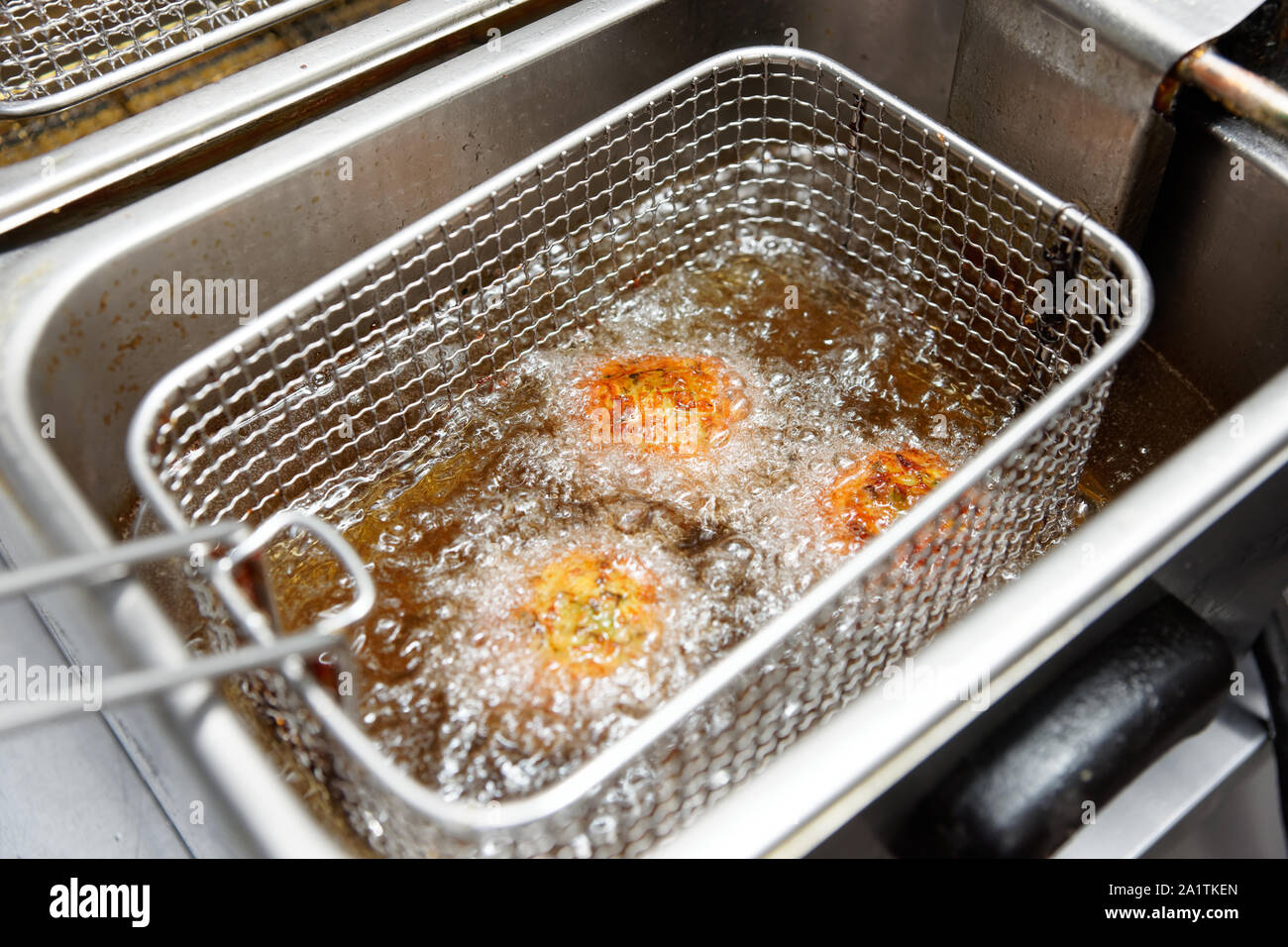 Deep frying a dish in fast food restaurant kitchen, greasy junk food ...