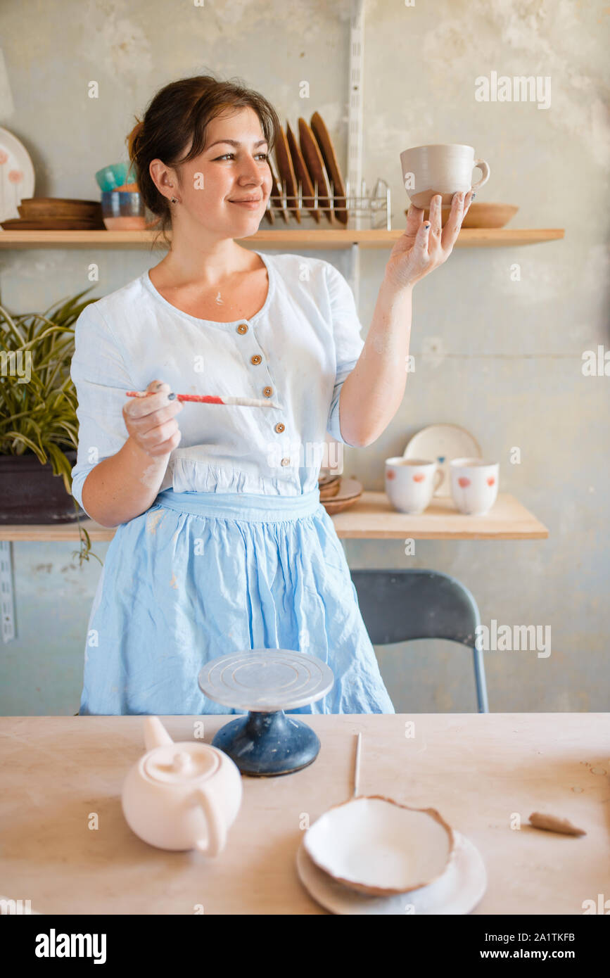 Ceramic artist paints pottery brush hi-res stock photography and images ...