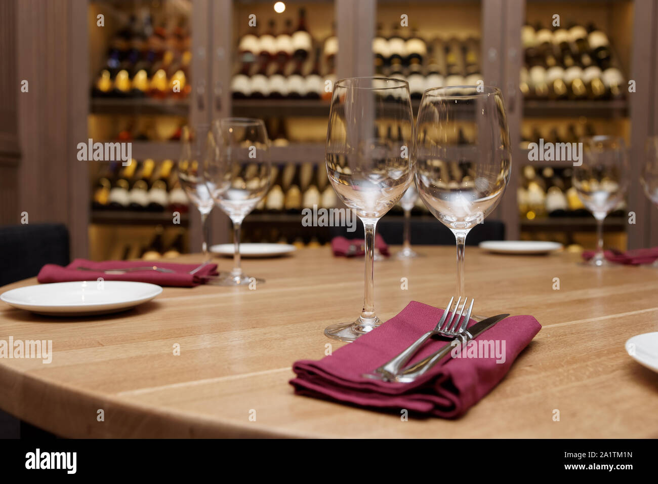 Restaurant table with wine cellar in blurred background Stock Photo - Alamy