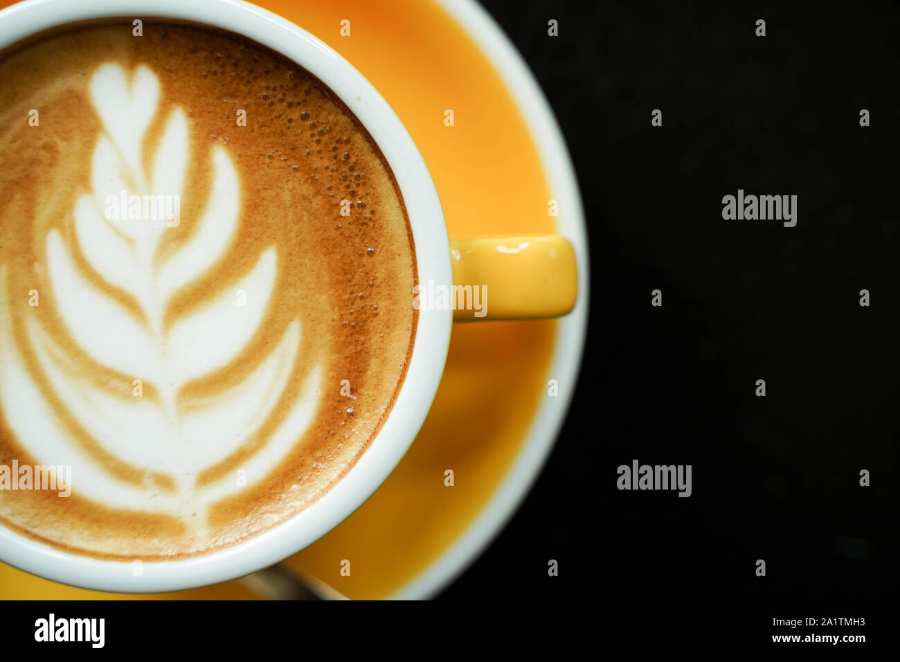 Coffee Latte leaf pattern face on black table Stock Photo - Alamy