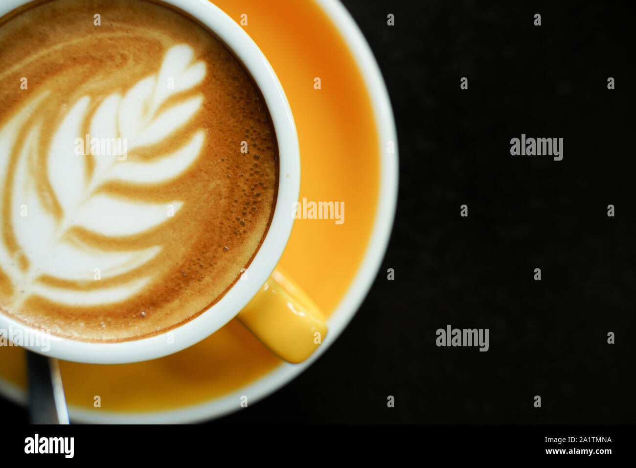 Coffee Latte leaf pattern face on black table Stock Photo - Alamy