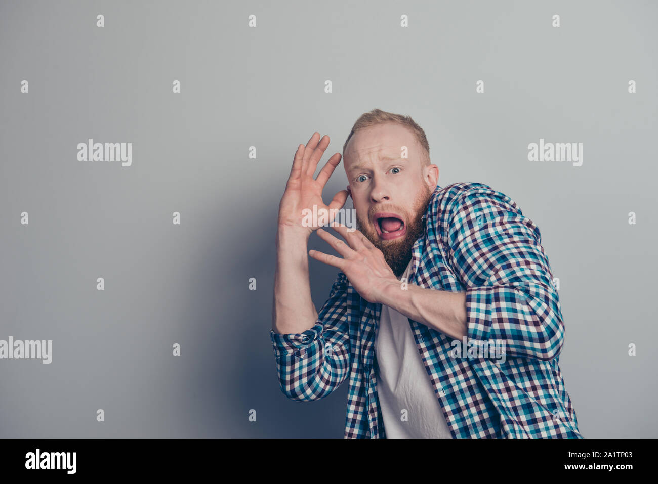 Attractive scared man hold hands near worried face with wide open mouth ...