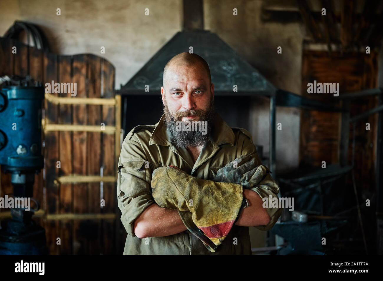 Portrait of a brutal, confident blacksmith, a man with a beard ...
