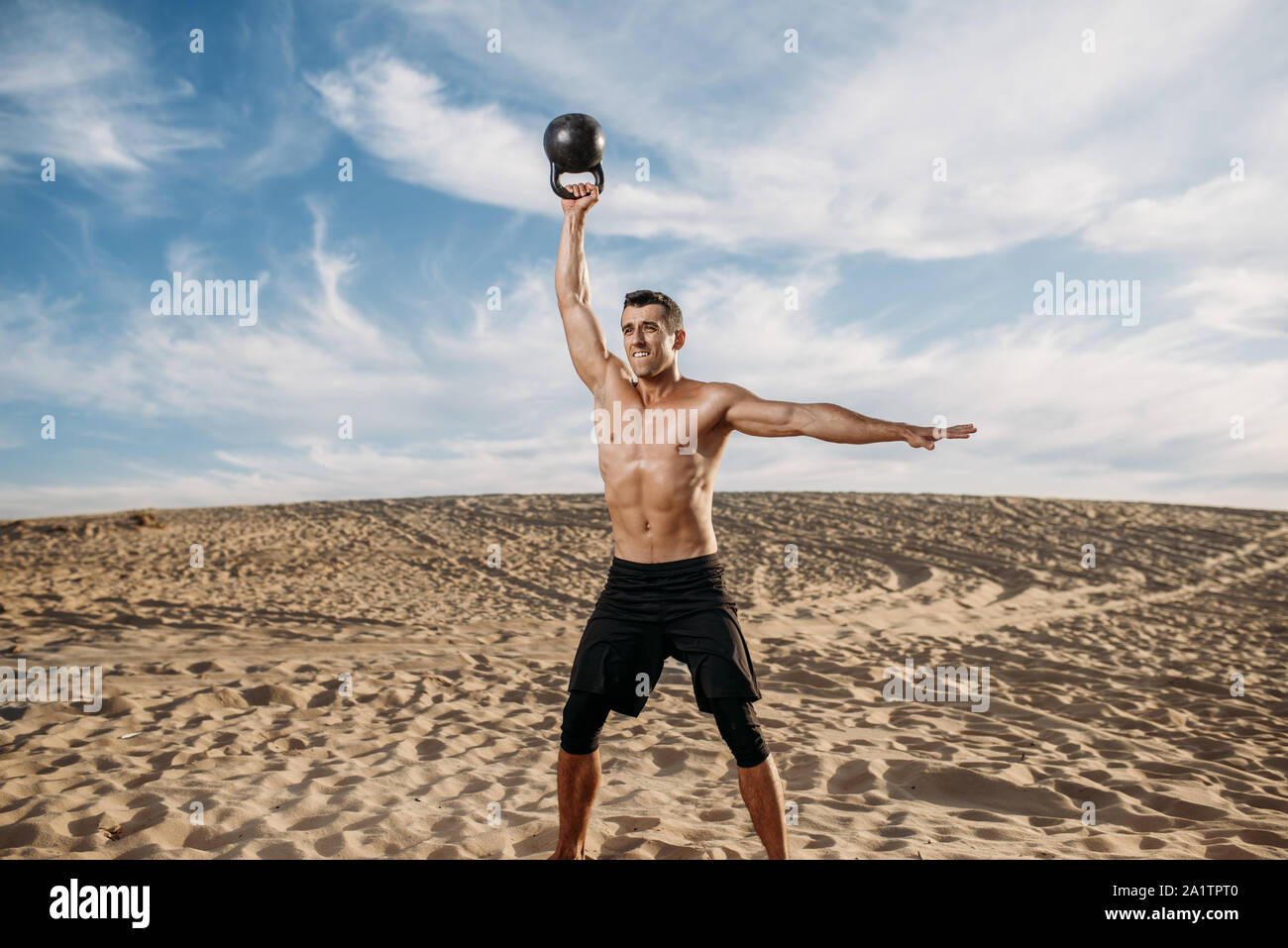 Male athlete doing exercise with weights in desert Stock Photo - Alamy