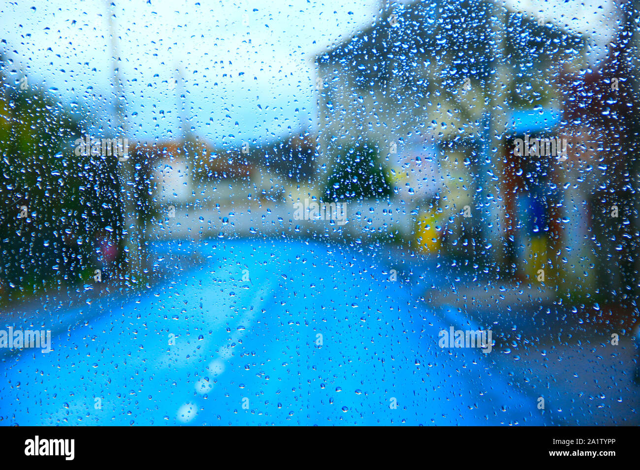 Rain outside window on city background. Drops of water dropping on ...
