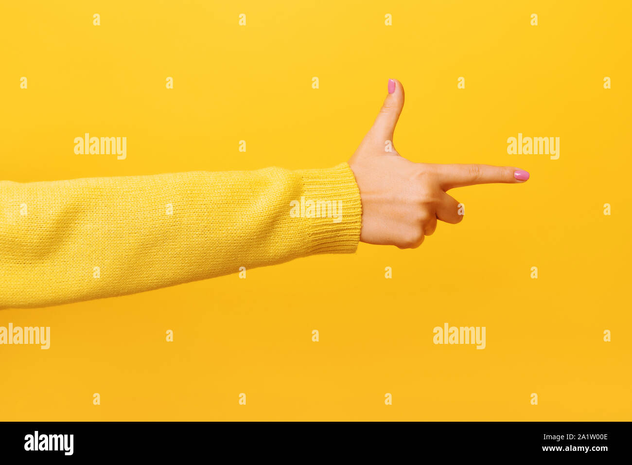 Woman's hand points a finger at something, over yellow background Stock ...