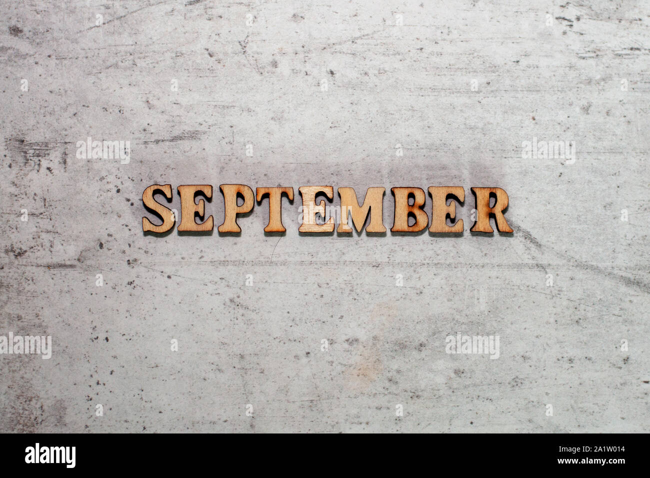 The word September laid out in wooden letters on a light background ...