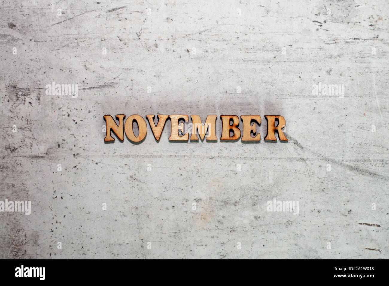 The word November laid out in wooden letters on a light background ...