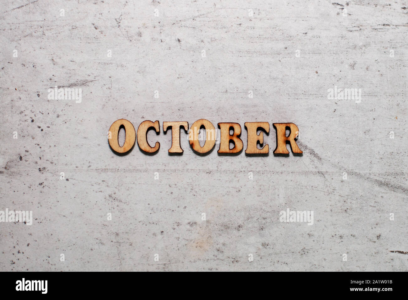 The word October laid out in wooden letters on a light background ...