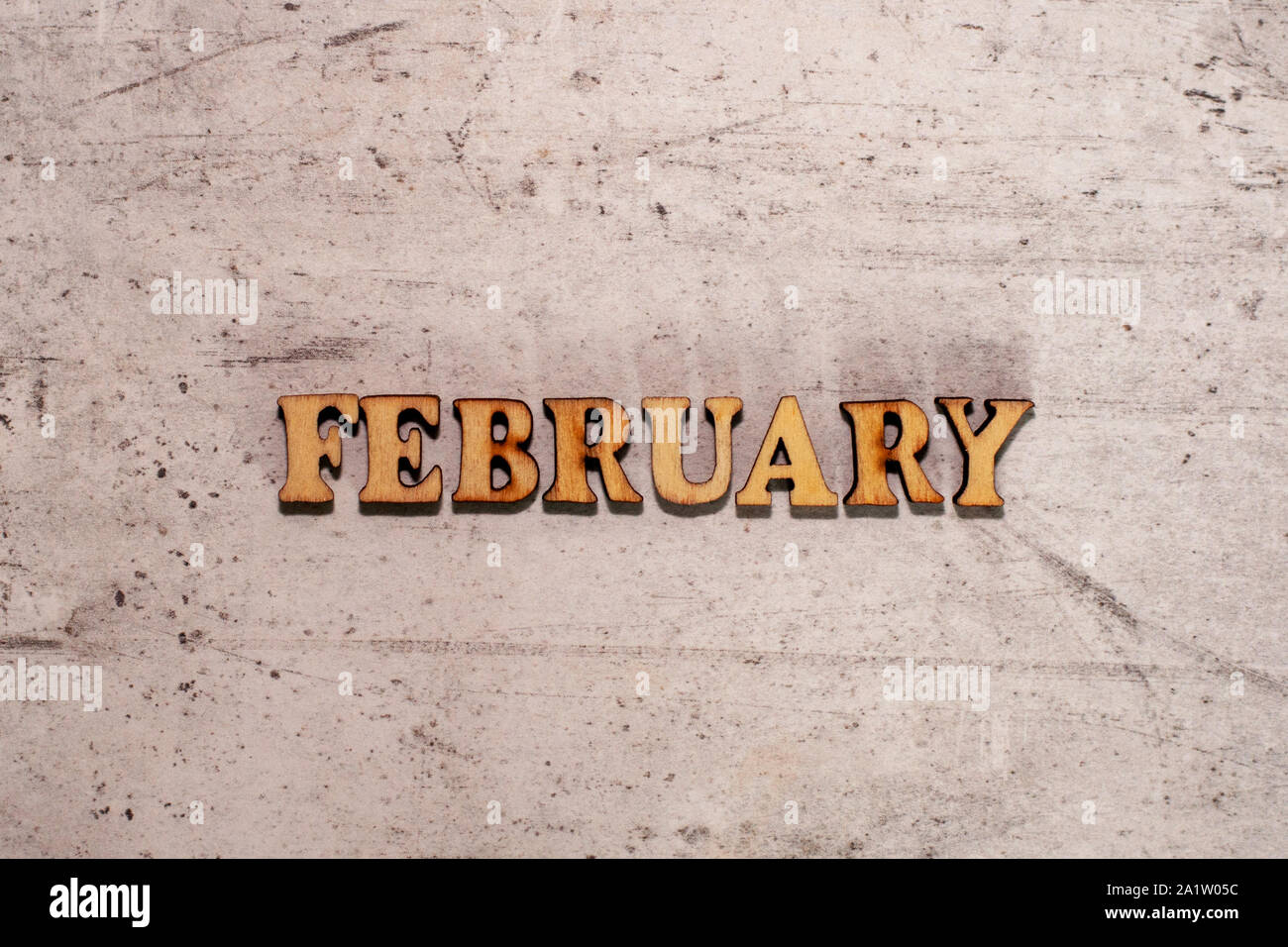 The word February laid out in wooden letters on a light background ...