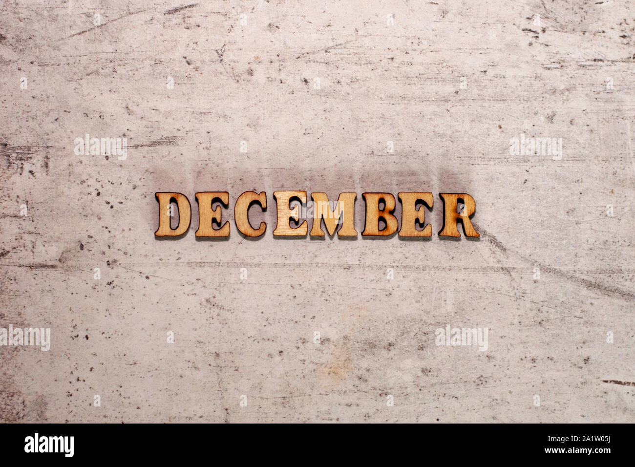 The word December laid out in wooden letters on a light background ...