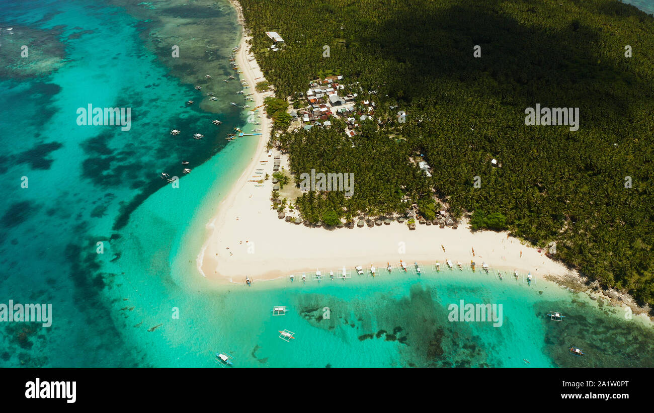 Sandy beach with tourists, palm trees and turquoise water on the island ...