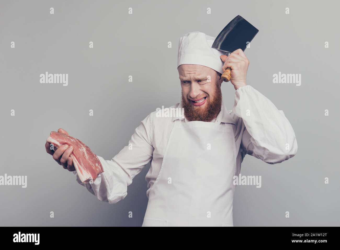 Portrait of attractive handsome butcher guy holding fresh meat a Stock ...