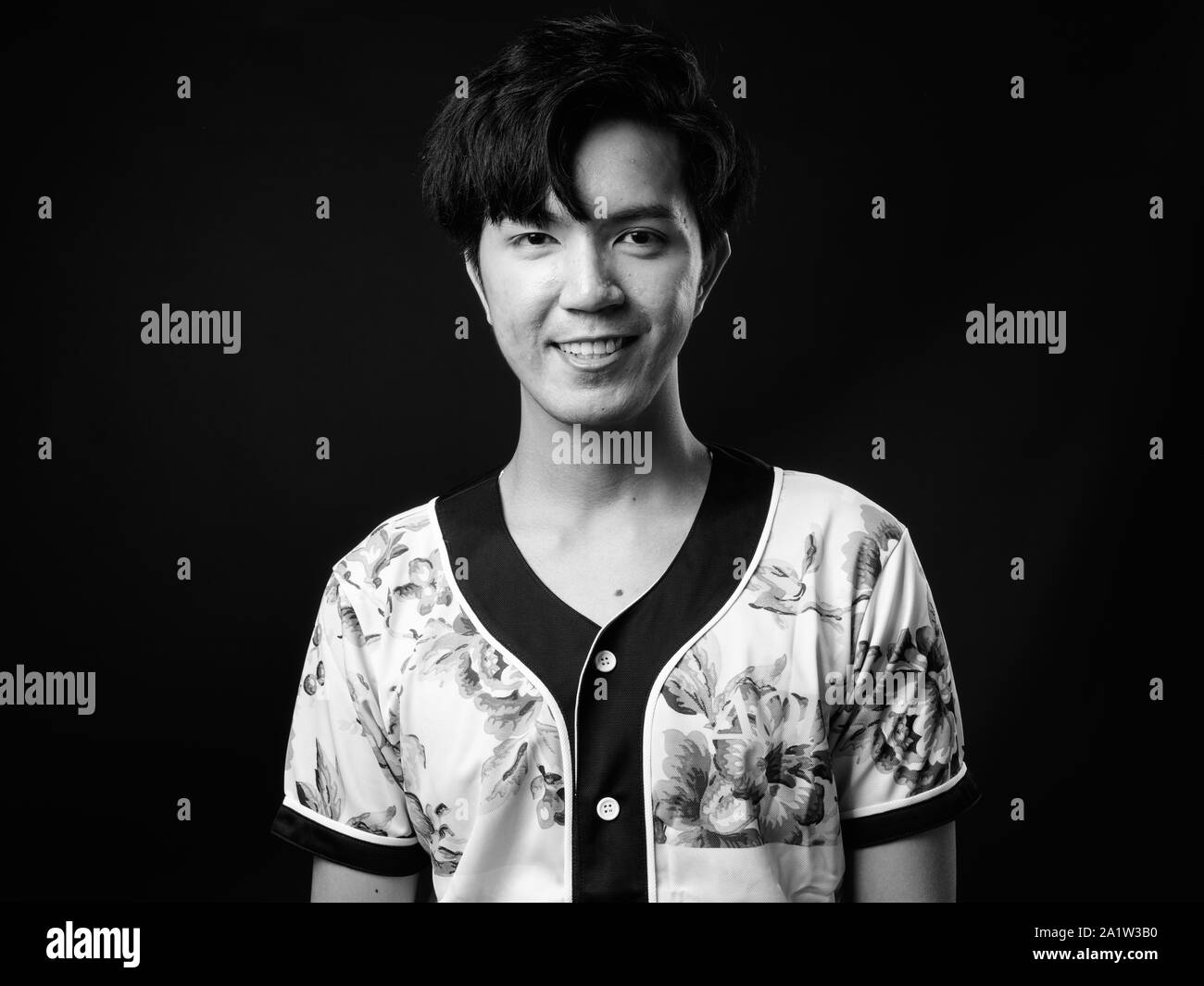 Young handsome Asian man smiling against black background Stock Photo ...