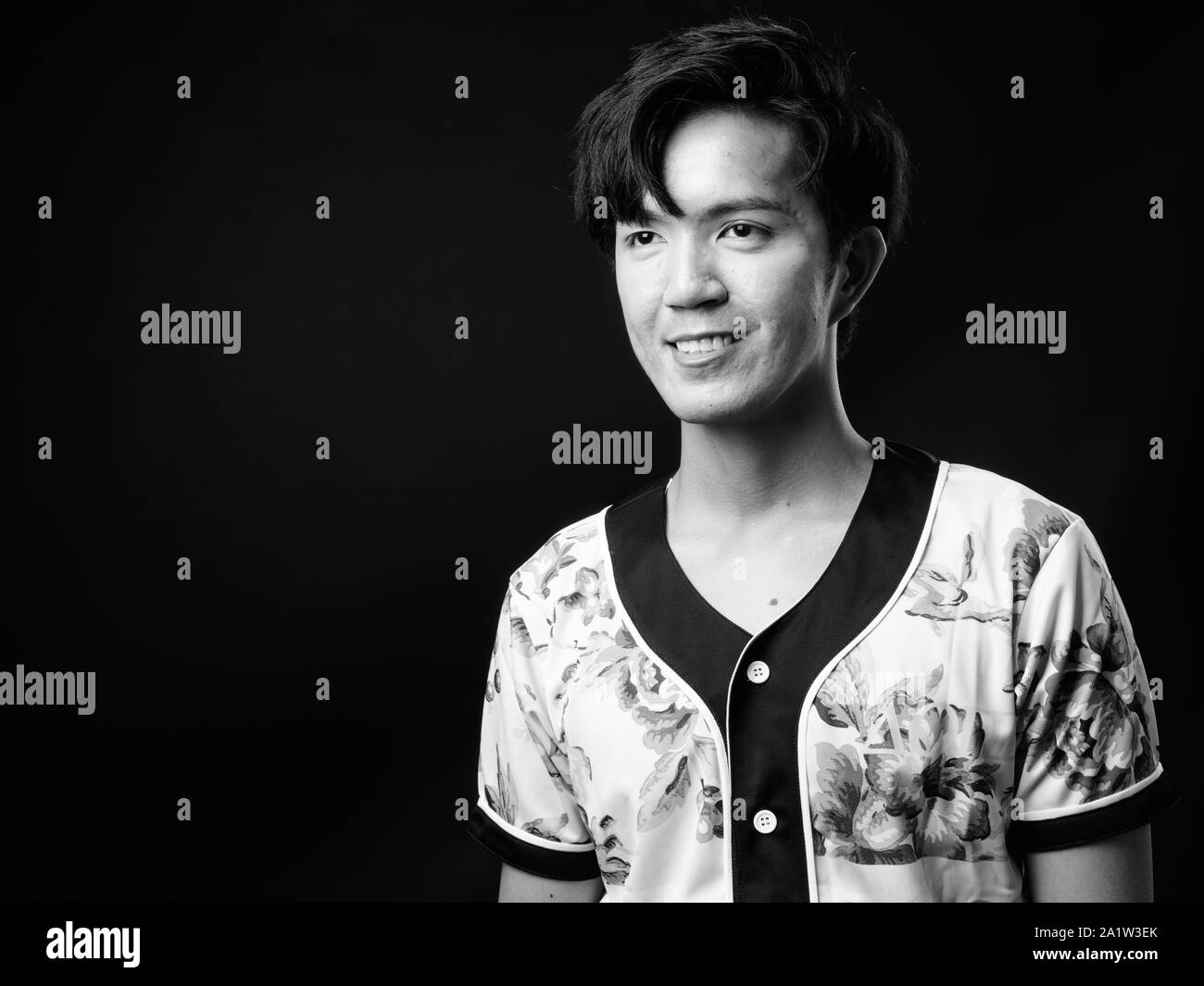 Young handsome Asian man smiling against black background Stock Photo ...