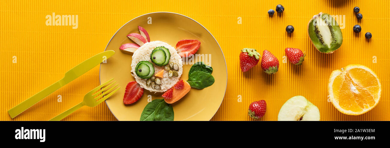 top view of plate with fancy cow made of food on colorful orange ...