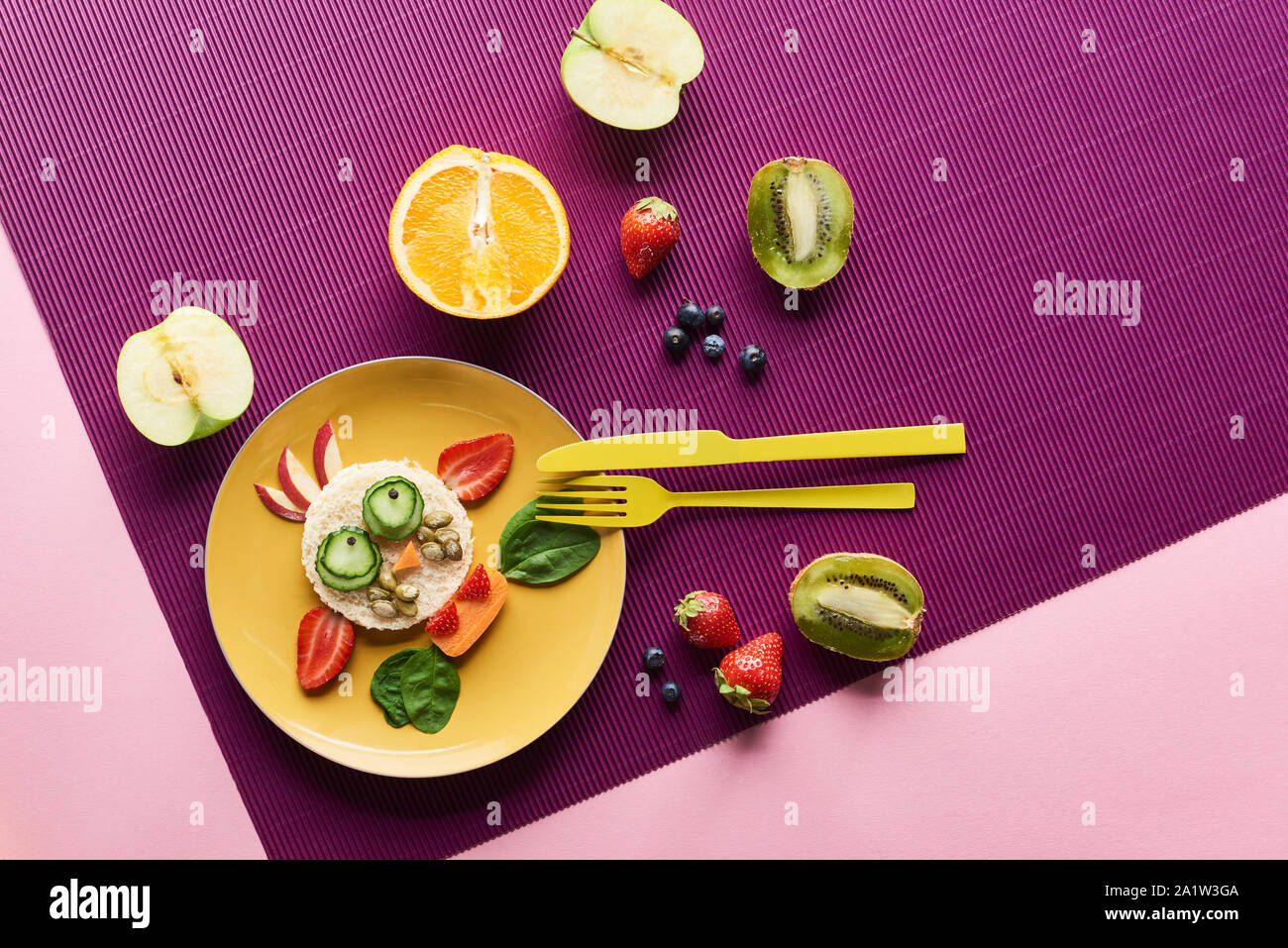 top view of plate with fancy cow made of food near fruits on purple ...
